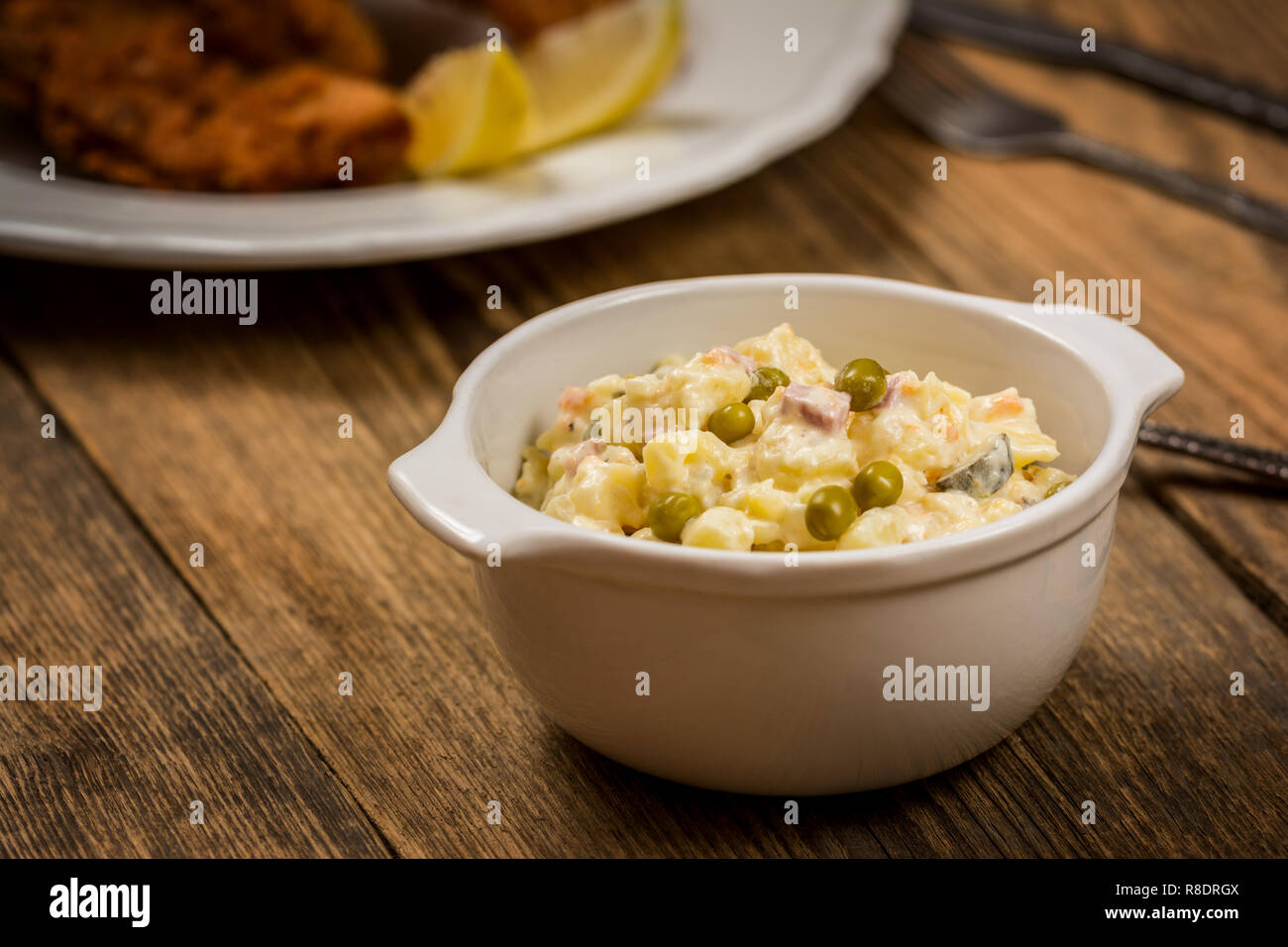 Traditional czech potato salad with mayonnaise and vegetables in white ...