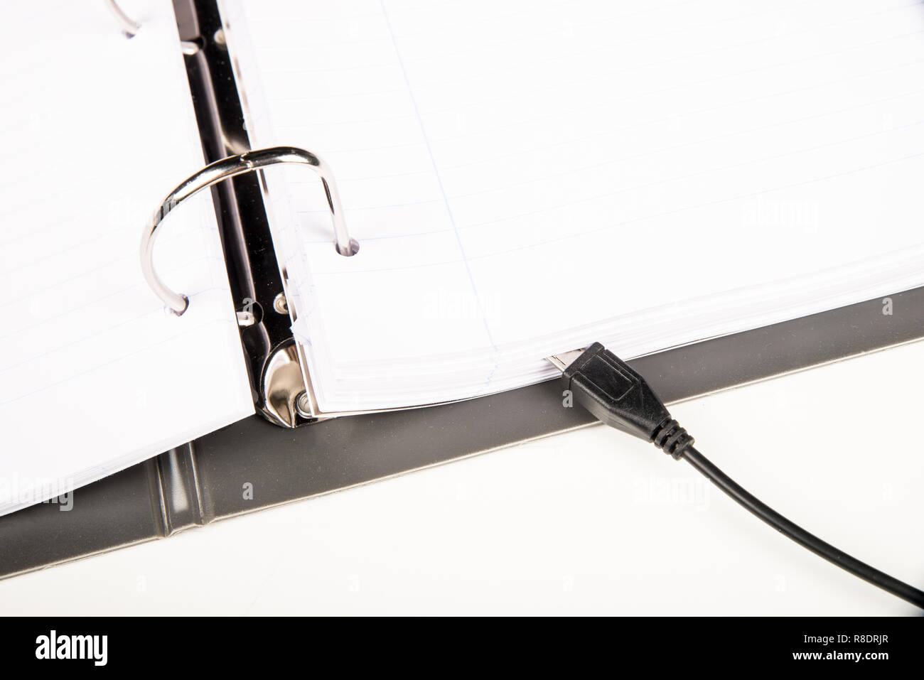 Paper notebook connected to a usb charger, a concept of analog vs ...