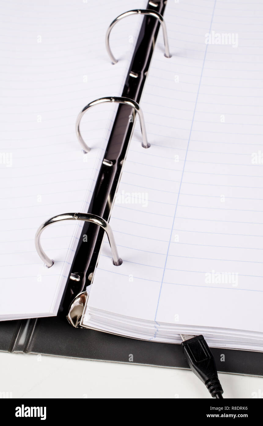 Paper notebook connected to a usb charger, a concept of analog vs ...