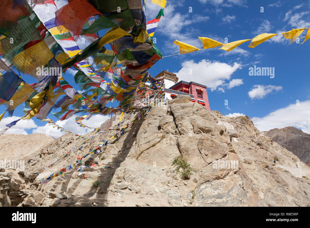 Colourful prayer flags and hill with Tsemo Maitreya Temple, Tsemo ...