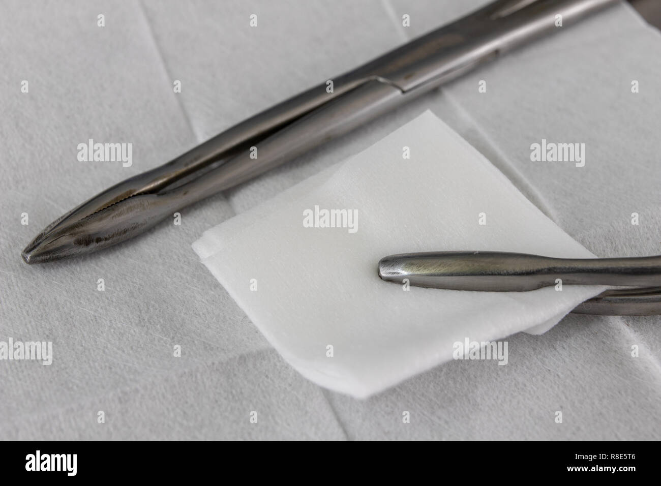 Sterile swab, pliers and a medical syringe on a hospital table ...
