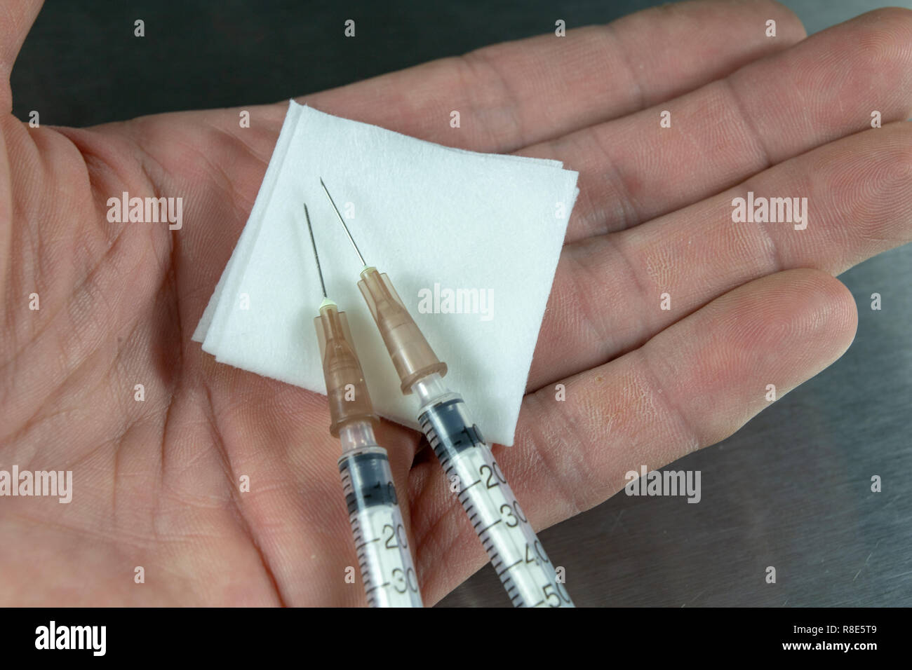 Sterile swab, pliers and a medical syringe on a hospital table ...