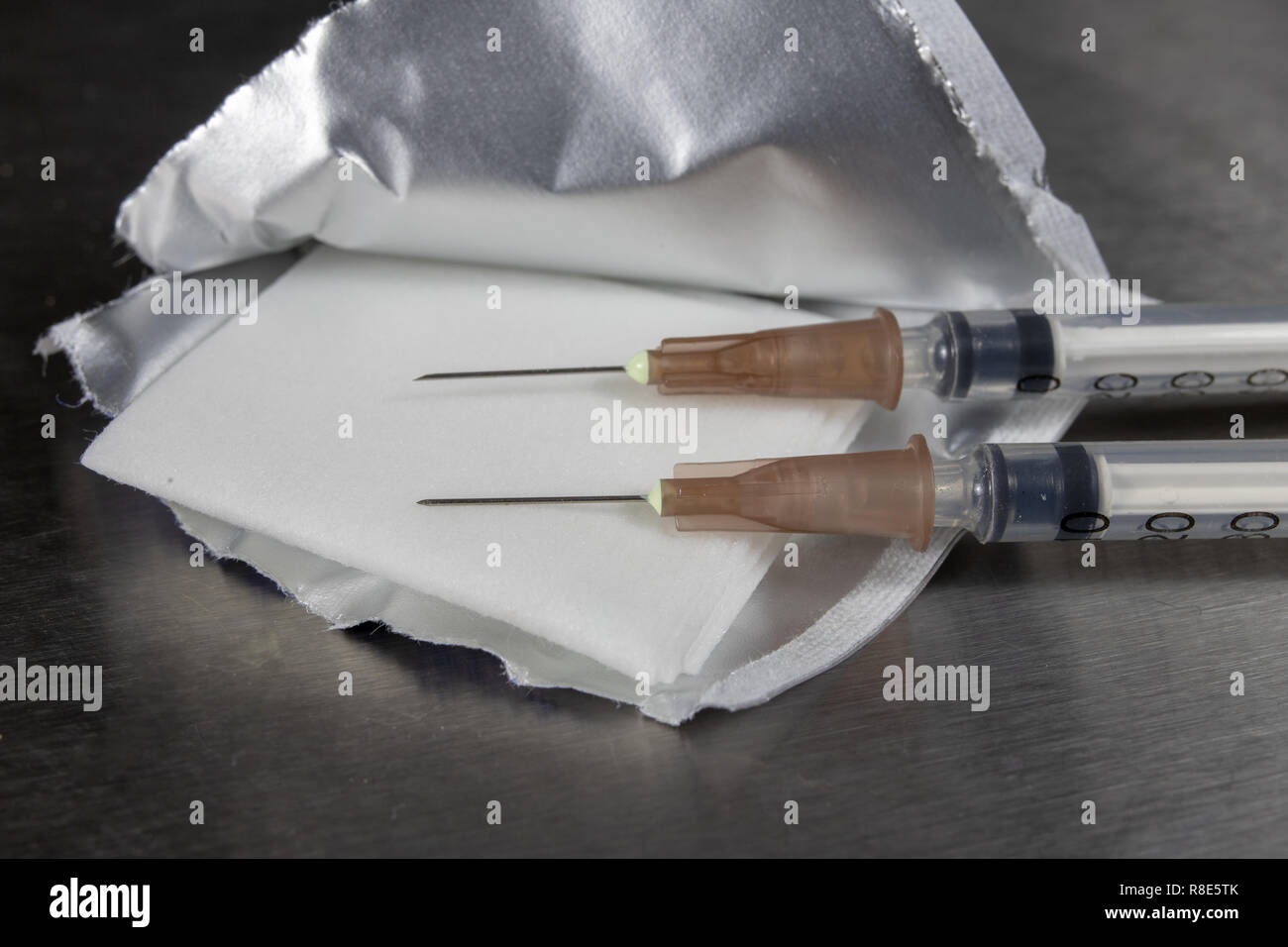 Sterile swab, pliers and a medical syringe on a hospital table ...