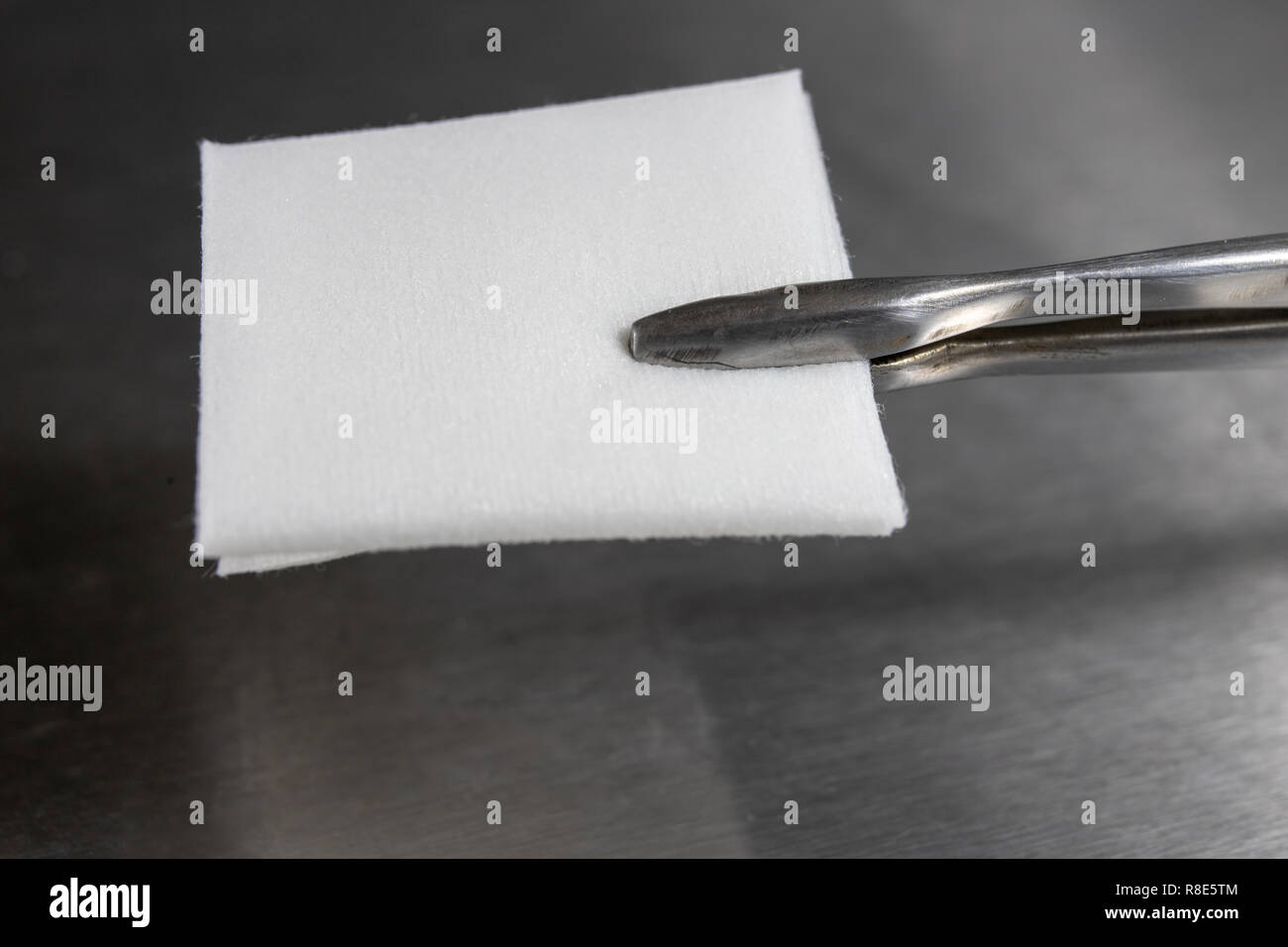 Sterile swab, pliers and a medical syringe on a hospital table ...