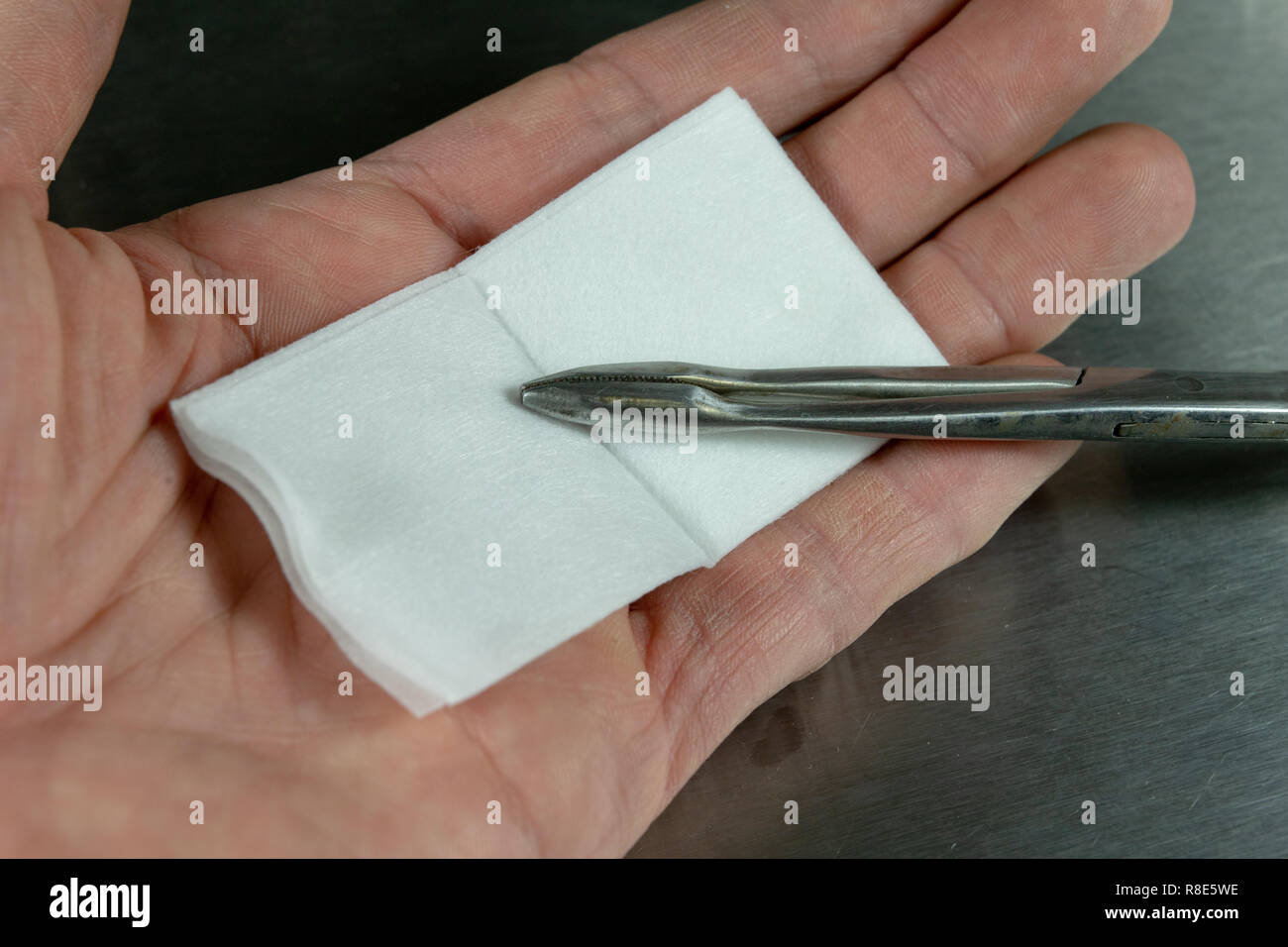 Sterile swab, pliers and a medical syringe on a hospital table ...