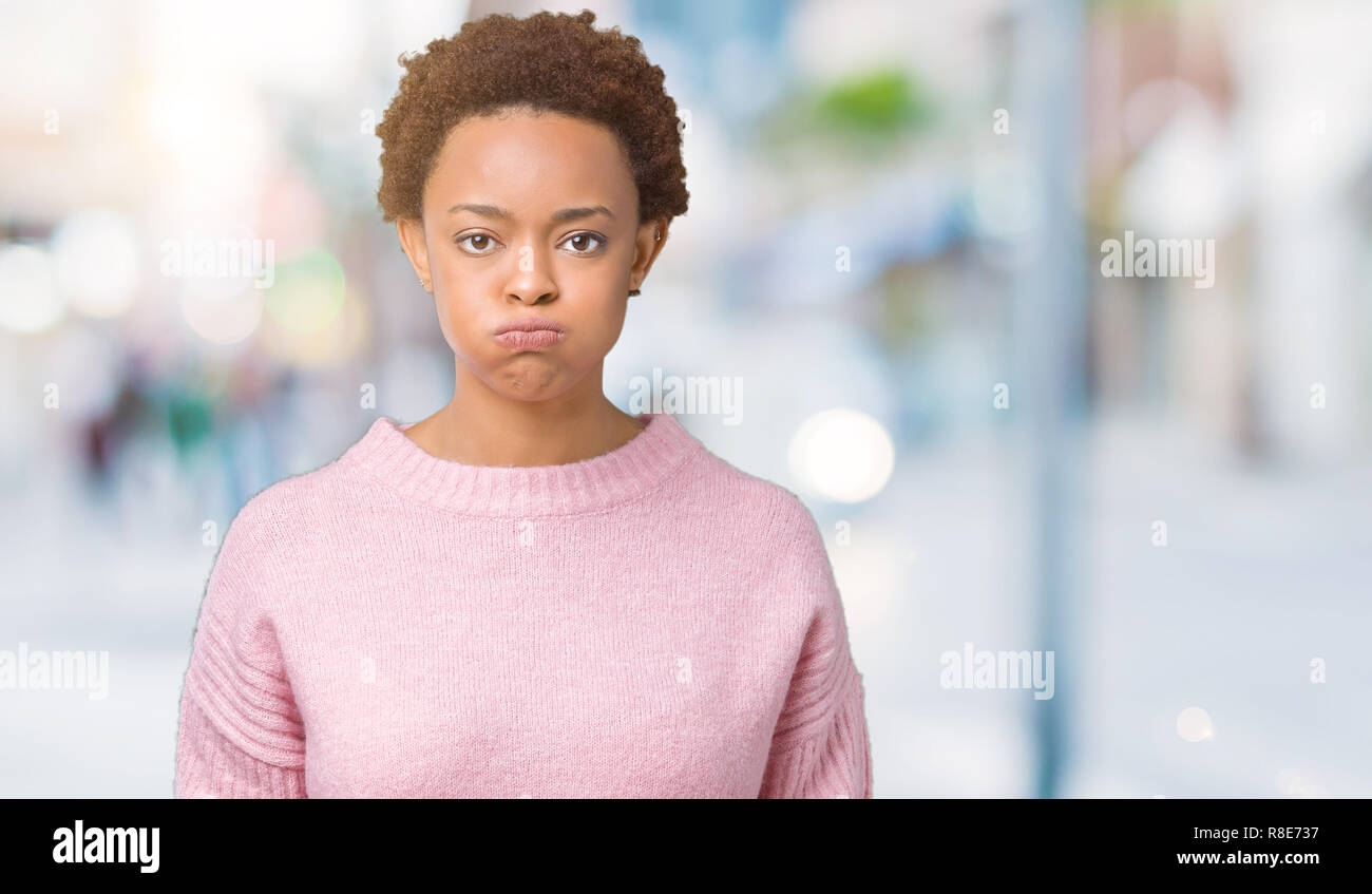 Beautiful young african american woman over isolated background puffing ...