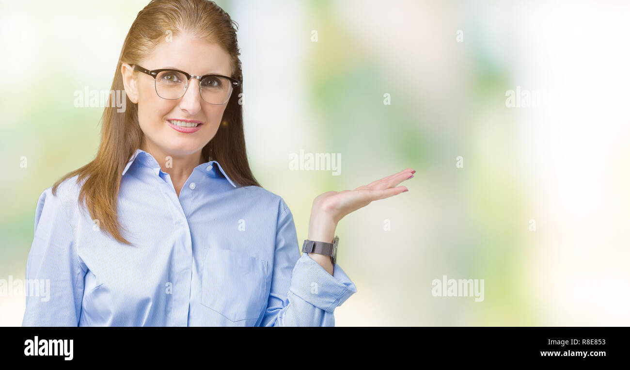 Beautiful middle age mature business woman wearing glasses over ...