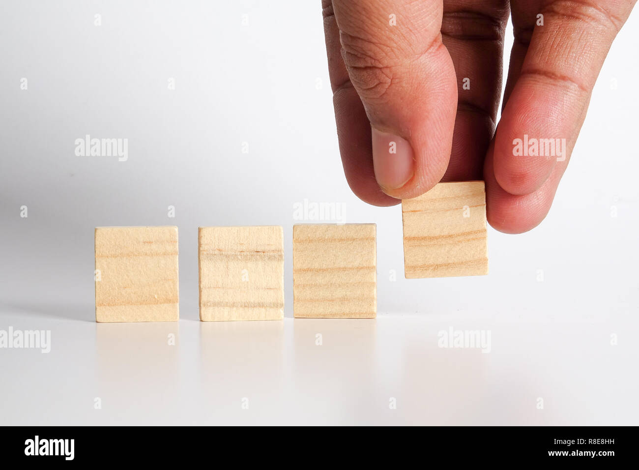 Close up man hand arranging wood block Stock Photo - Alamy