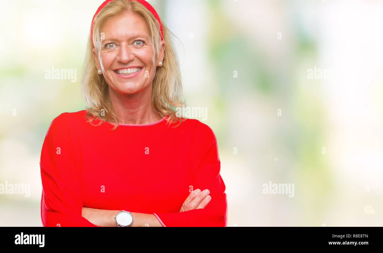 Middle age blonde woman over isolated background happy face smiling with crossed arms looking at ...