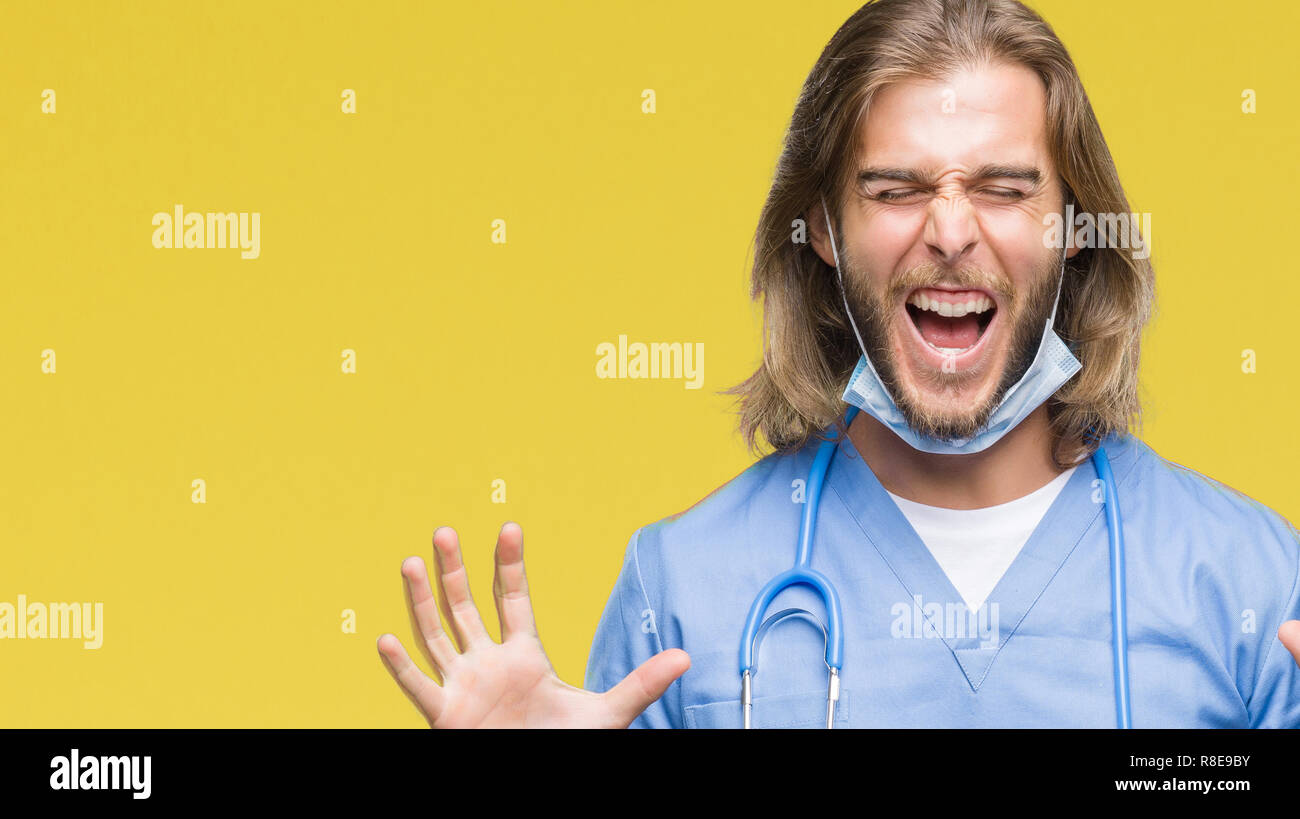 Young handsome doctor man with long hair over isolated background ...
