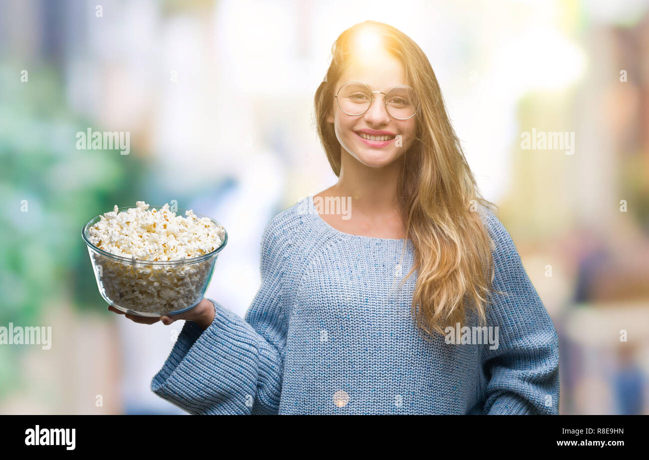 Young beautiful blonde woman eating popcorn over isolated background ...