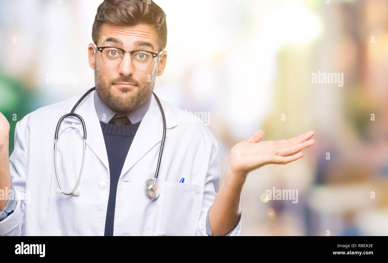 Young handsome doctor man over isolated background clueless and ...