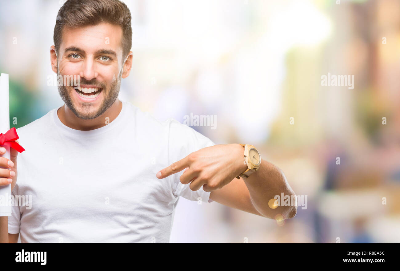 Young handsome man holding degree over isolated background with ...