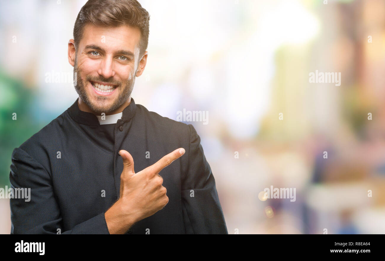 Young catholic christian priest man over isolated background cheerful ...