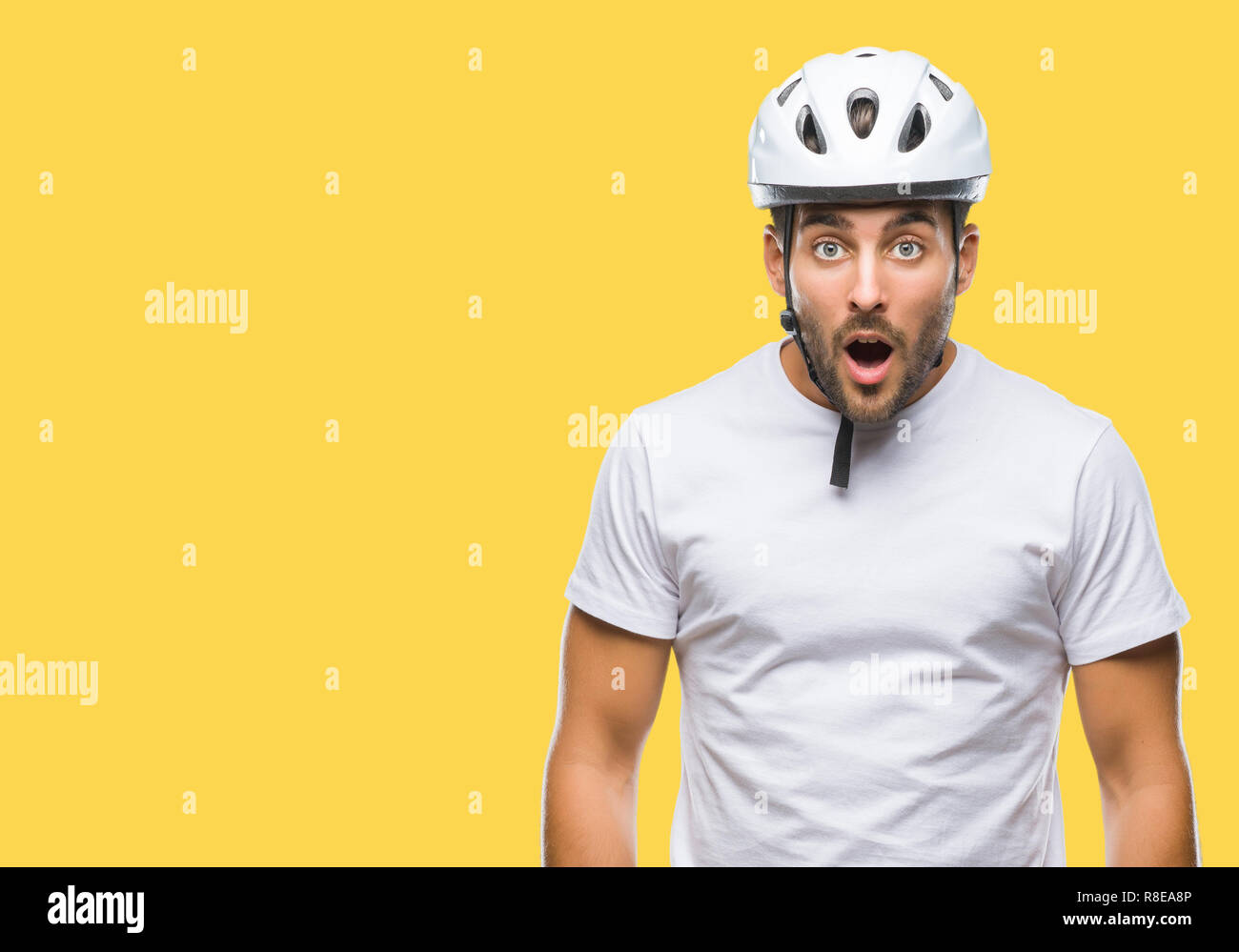 Young handsome man wearing cyclist safety helmet over isolated background afraid and shocked ...