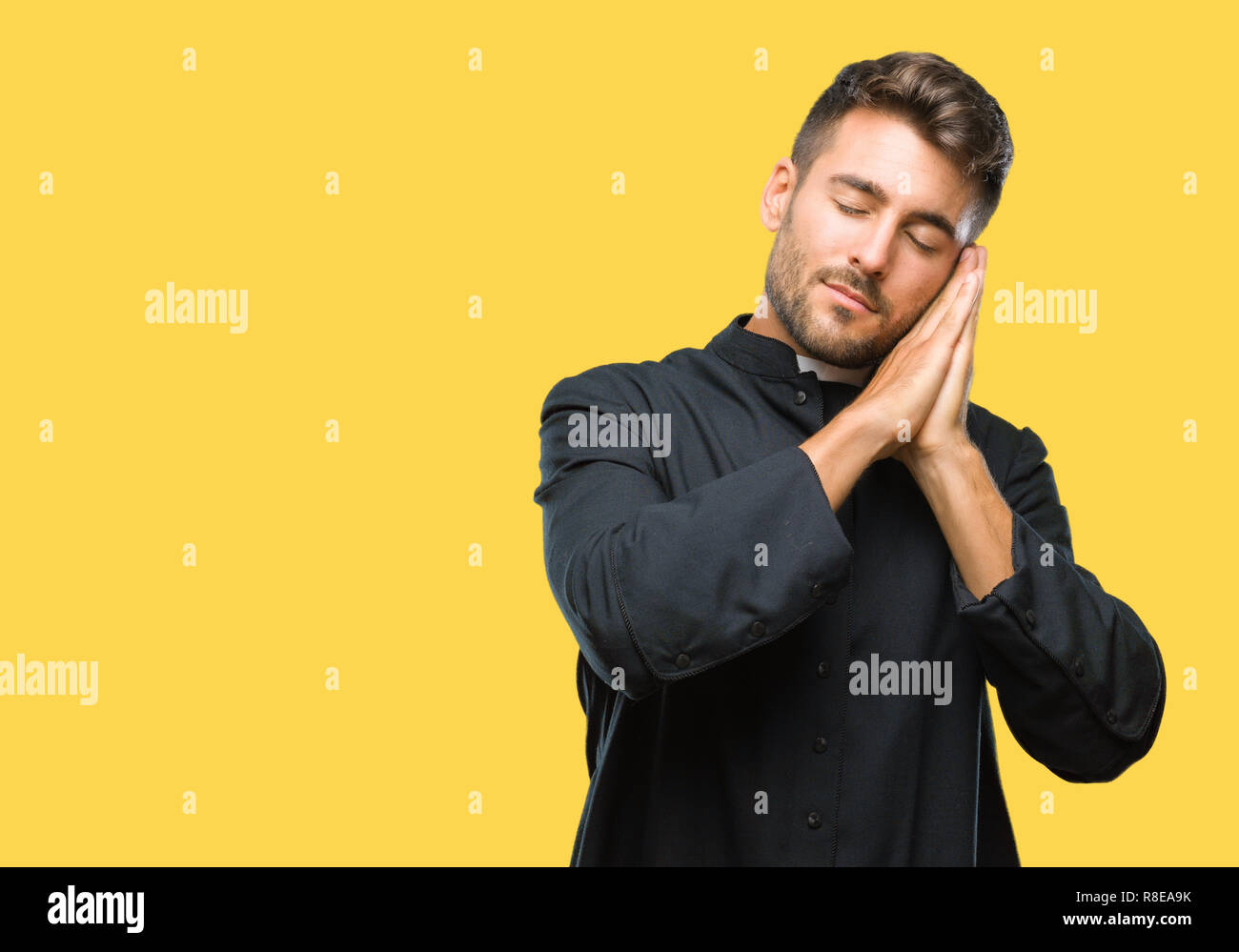 Young catholic christian priest man over isolated background sleeping ...