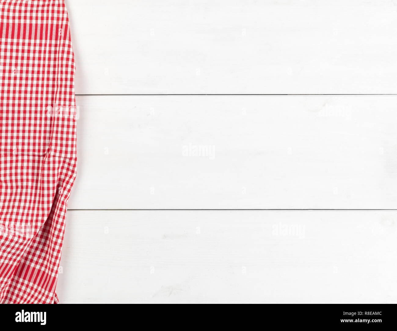 Red checkered dishcloth on white wooden plank table flat lay top view ...