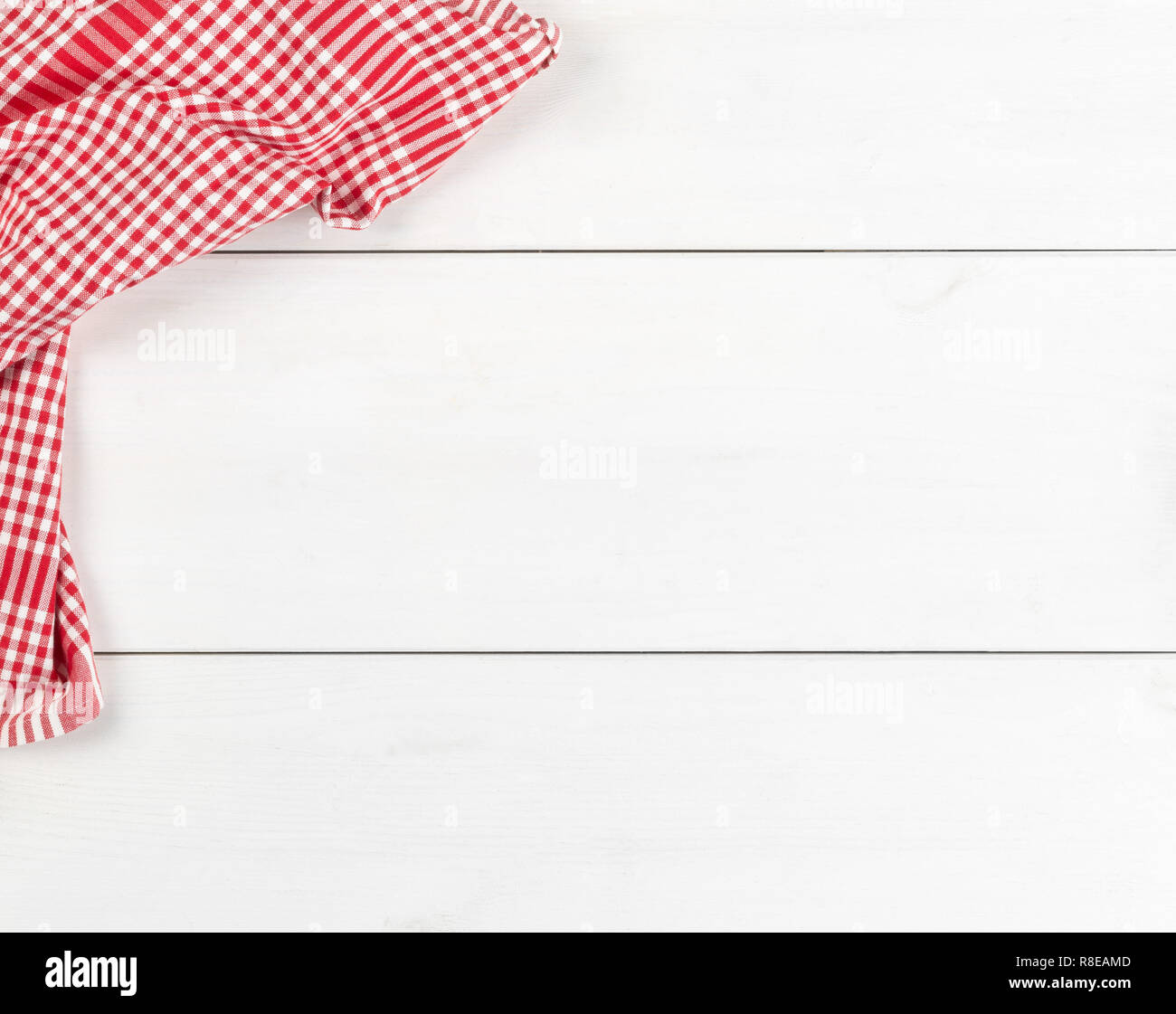 Red checkered dishcloth on white wooden plank table flat lay top view ...