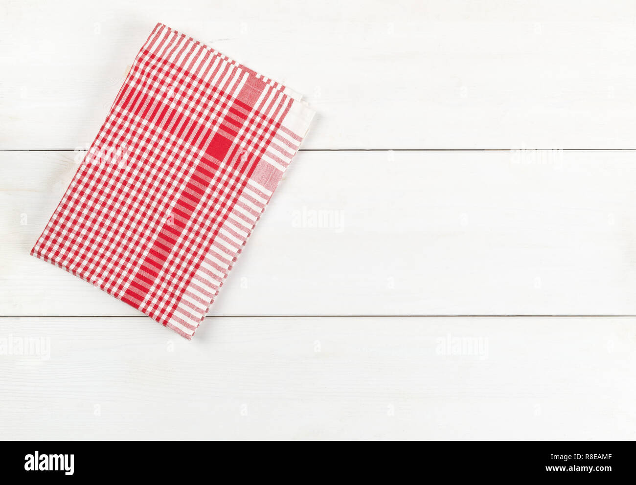 Red checkered dishcloth on white wooden plank table flat lay top view ...
