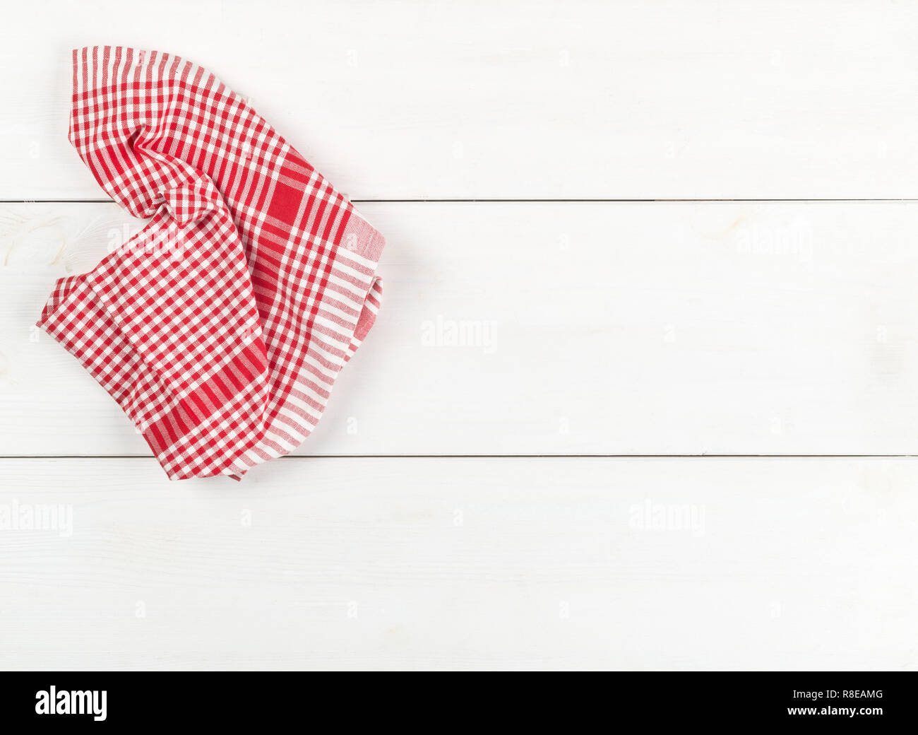 Red checkered dishcloth on white wooden plank table flat lay top view ...