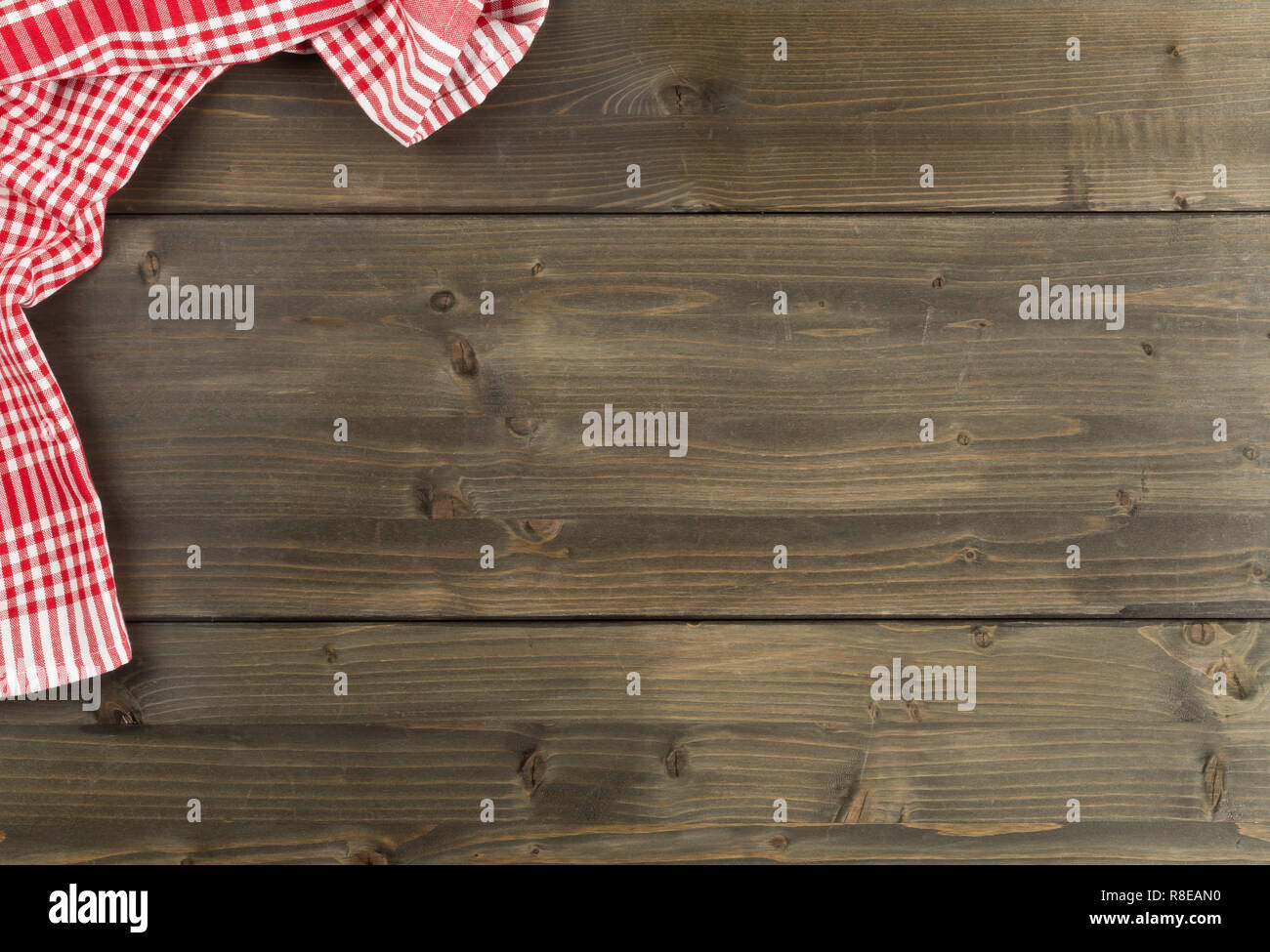 Red checkered dishcloth on brown rustic wooden plank table flat lay top ...
