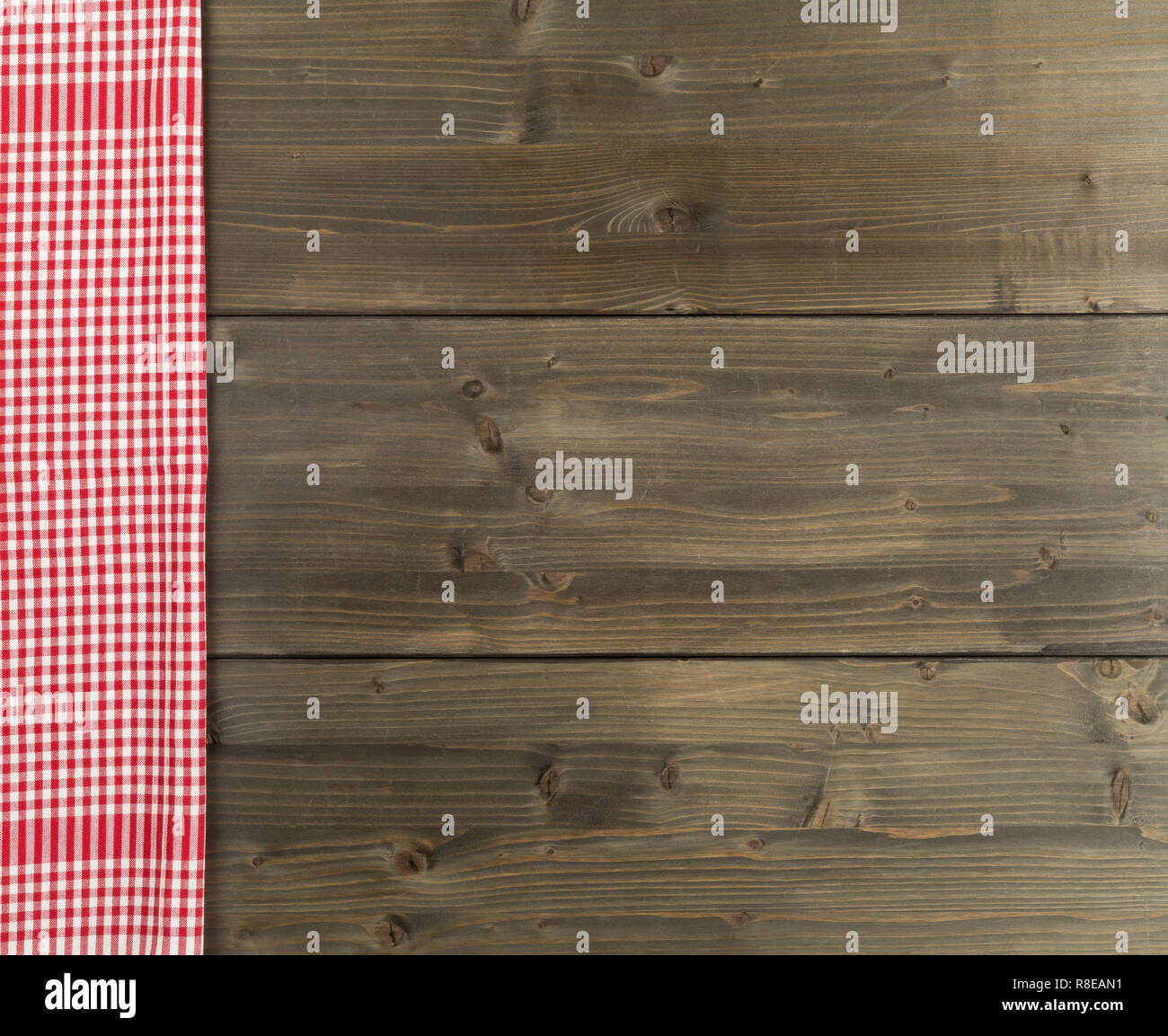 Red checkered dishcloth on brown rustic wooden plank table flat lay top ...