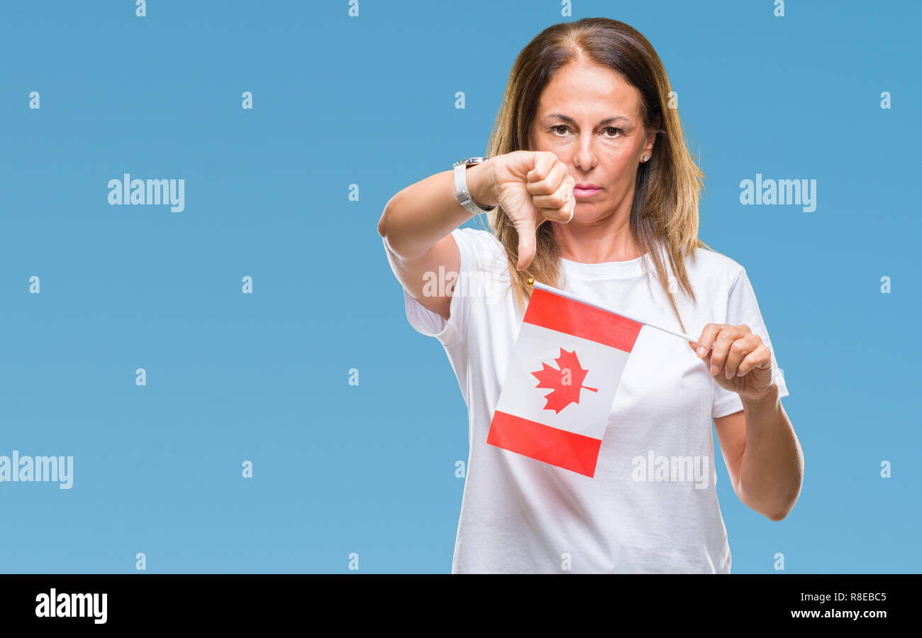 Middle age hispanic woman holding flag of Canada over isolated ...