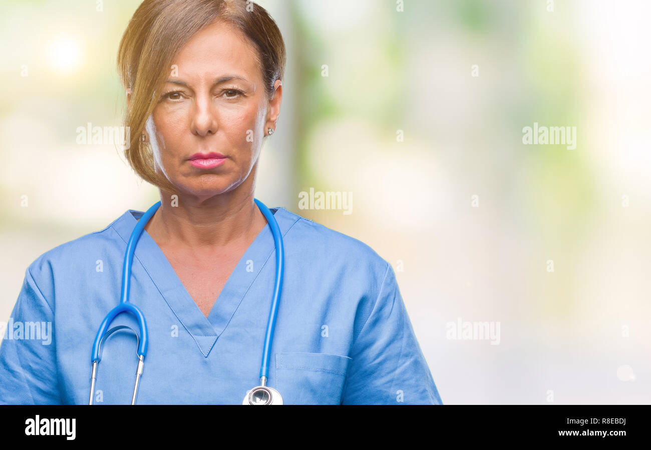 Middle age senior nurse doctor woman over isolated background skeptic ...