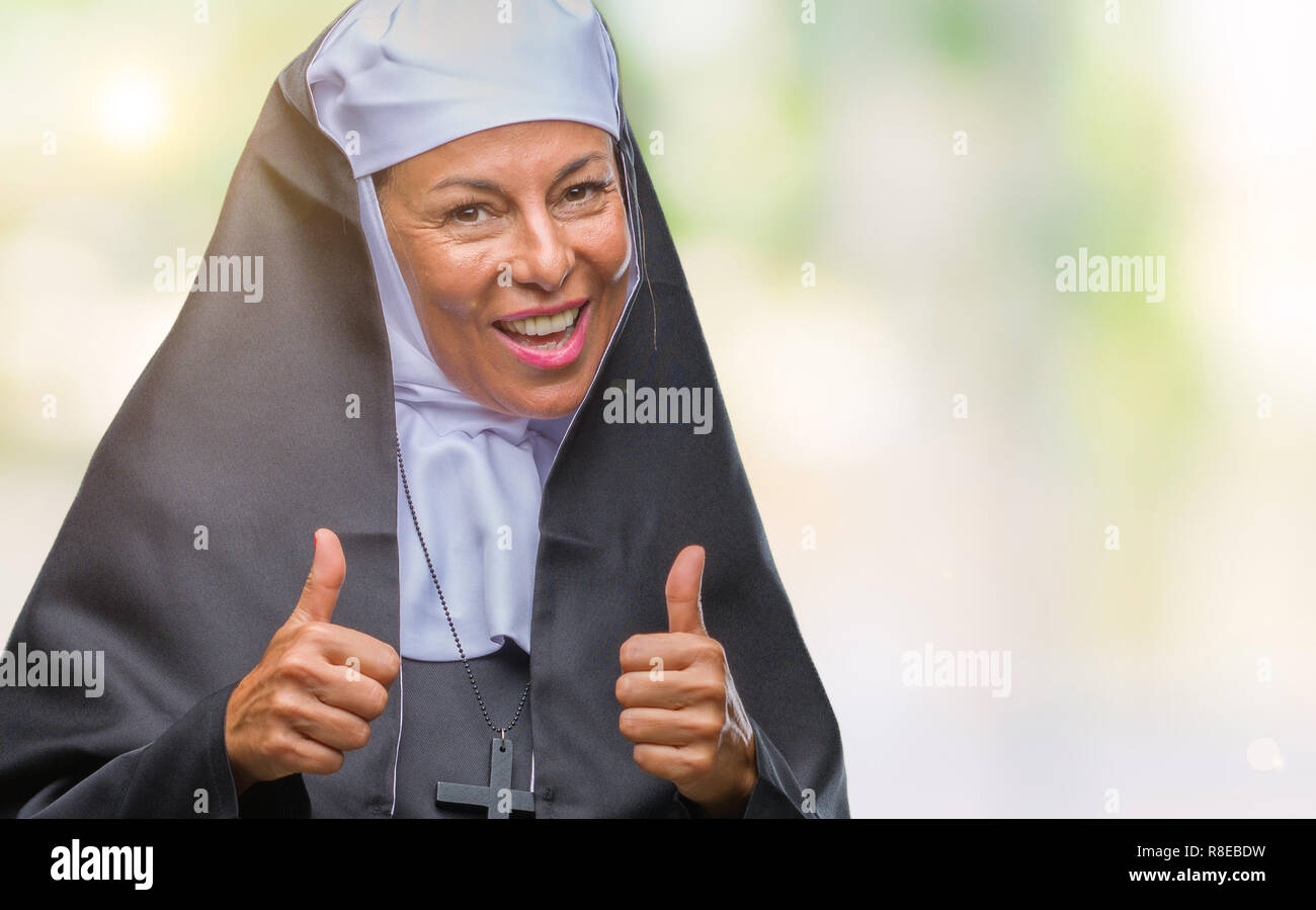 Middle age senior christian catholic nun woman over isolated background ...