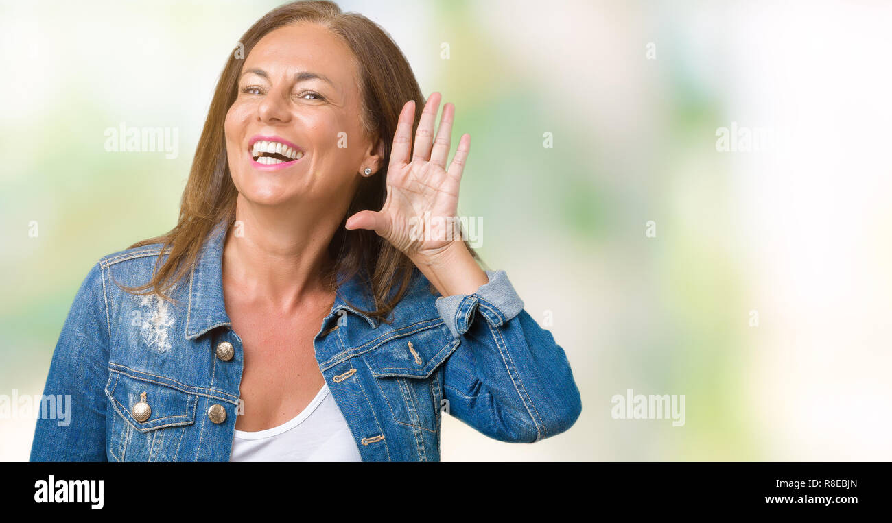 Beautiful middle age woman wearing casual denim jacket over isolated ...