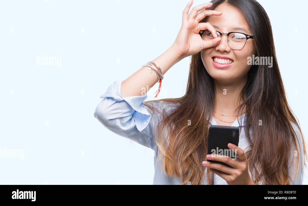 Young asian woman texting using smartphone over isolated background ...