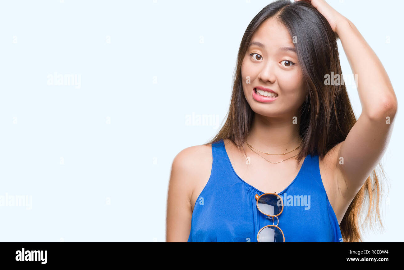 Young asian woman over isolated background confuse and wonder about ...