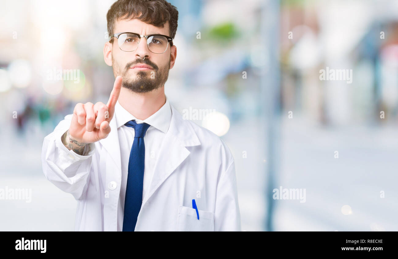 Young professional scientist man wearing white coat over isolated ...