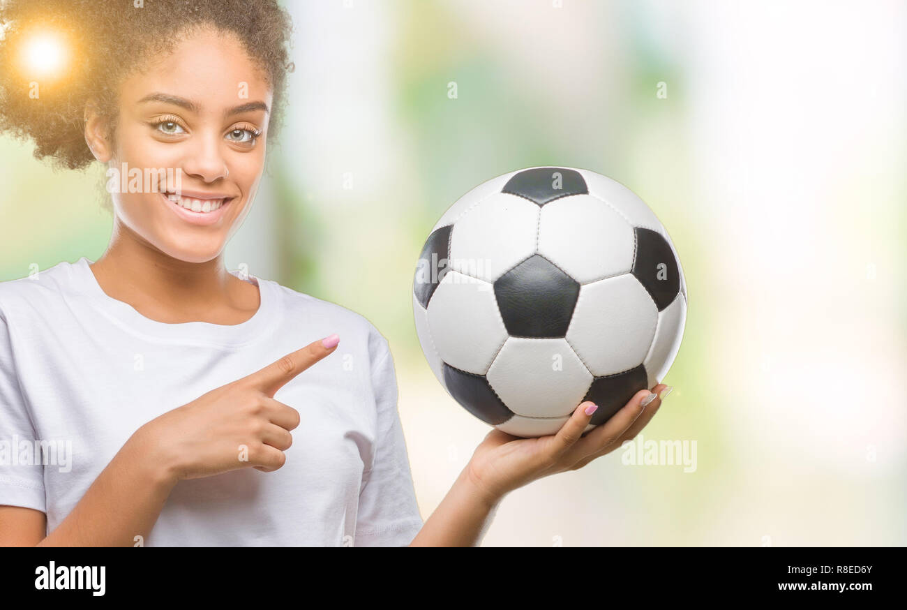 Young beautiful afro american holding soccer football ball over ...
