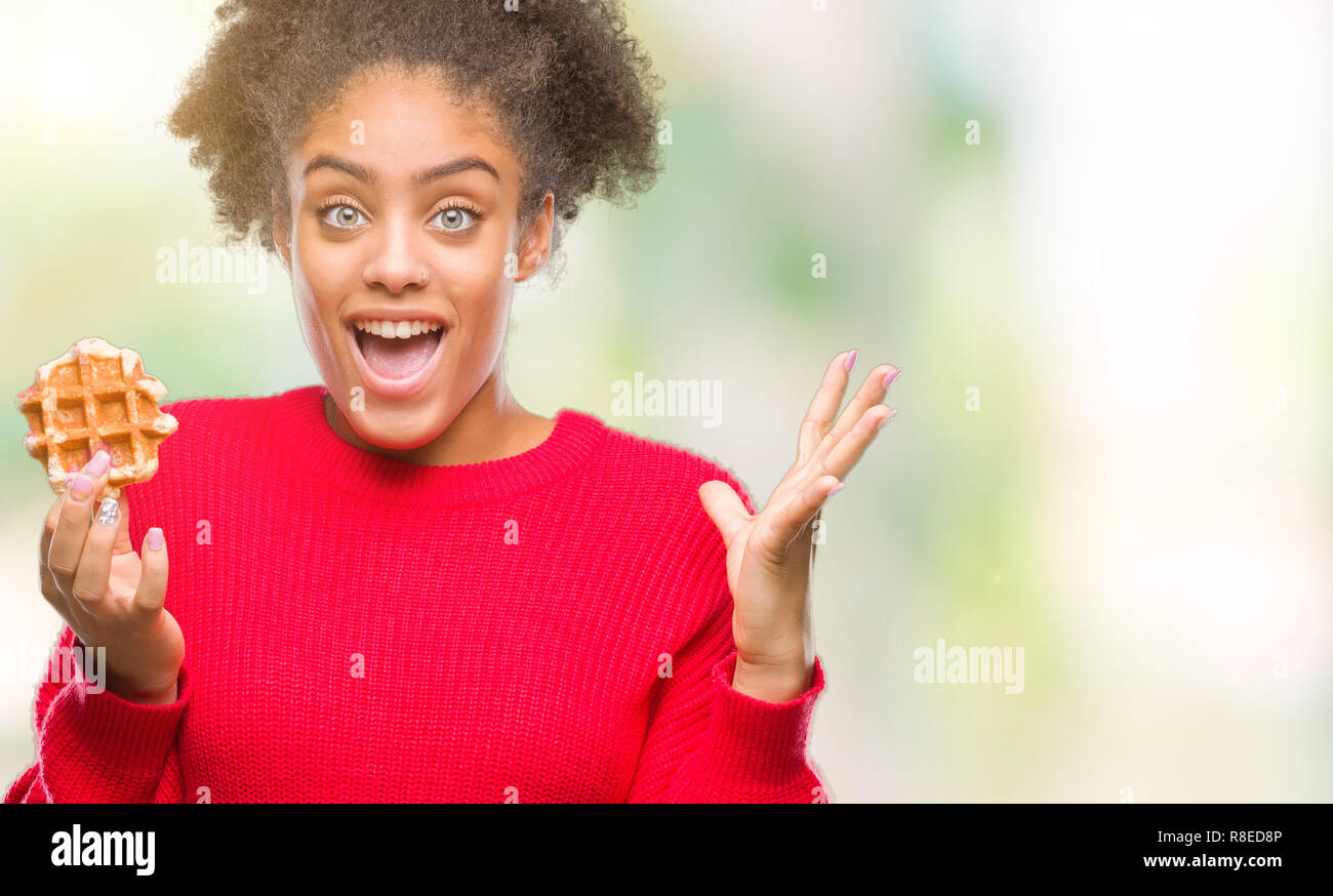 Young beautiful afro american woman eating waffle over isolated ...