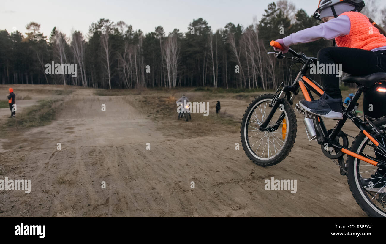 One caucasian children rides bike road track in dirt park. Girl riding ...