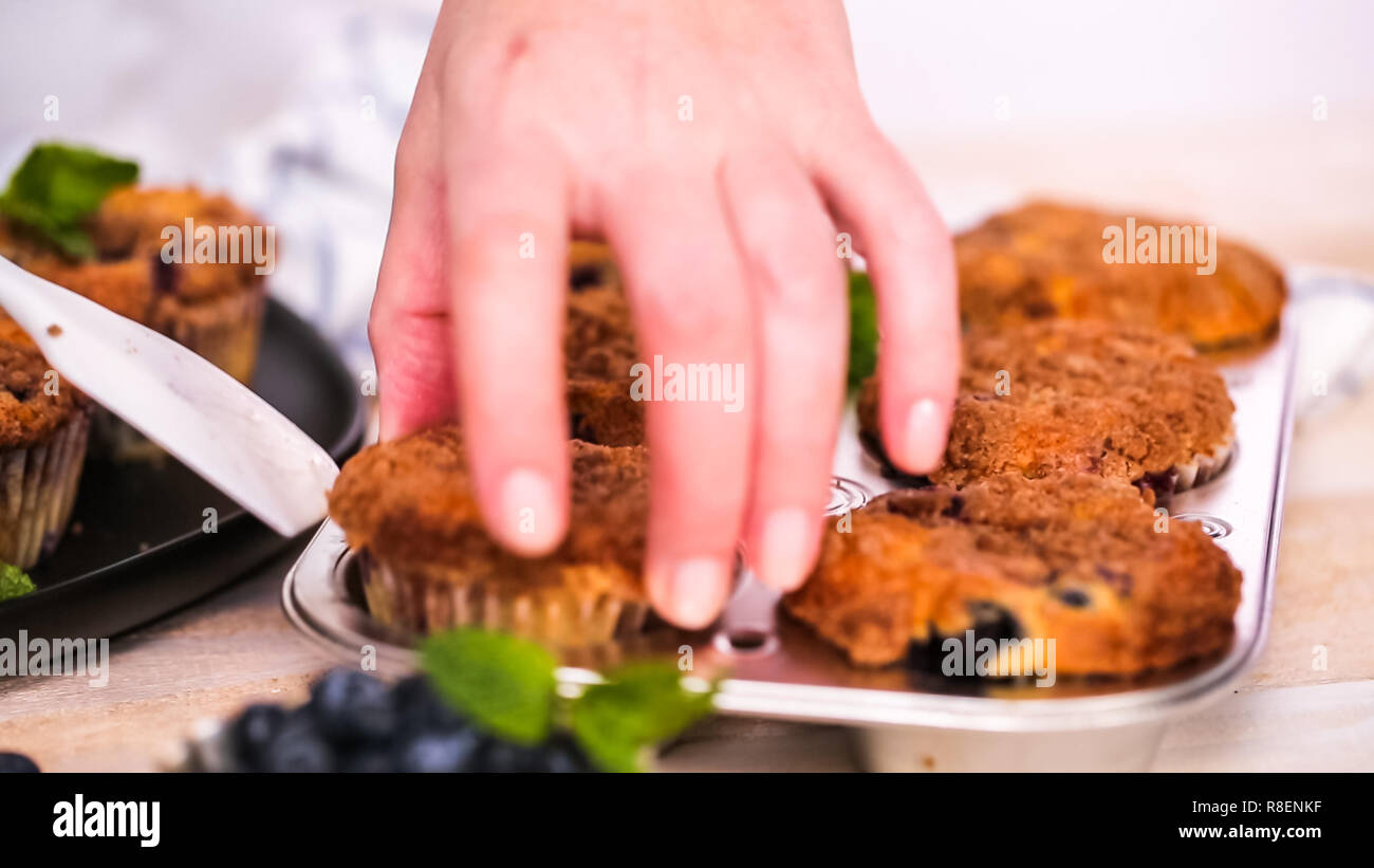Taking blueberry muffins out of metal muffin pan Stock Photo - Alamy