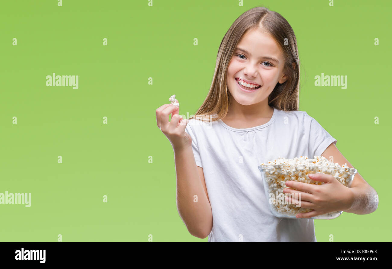 Young beautiful girl eating popcorn snack isolated background with a ...
