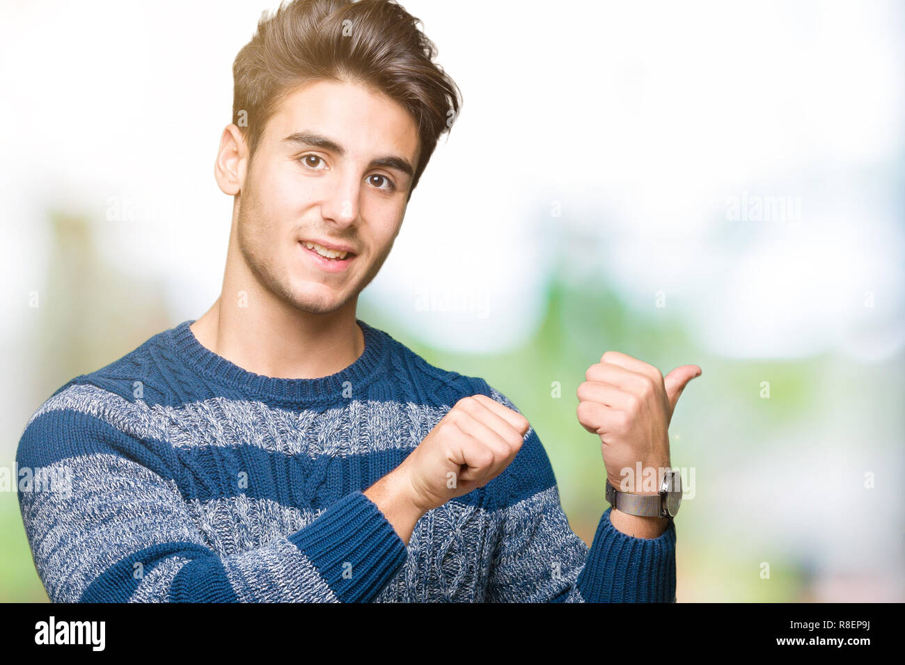 Young handsome man over isolated background Pointing to the back behind ...