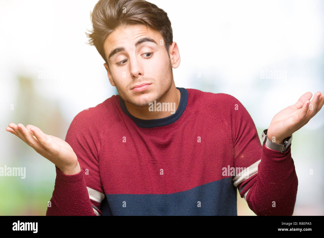 Young handsome man over isolated background clueless and confused ...
