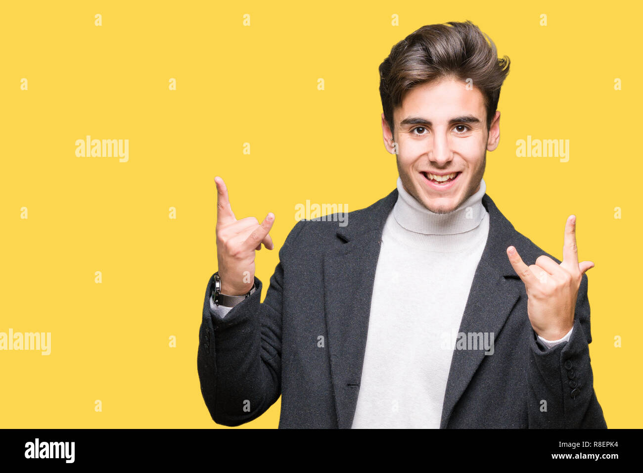 Young elegant man wearing winter coat over isolated background shouting ...