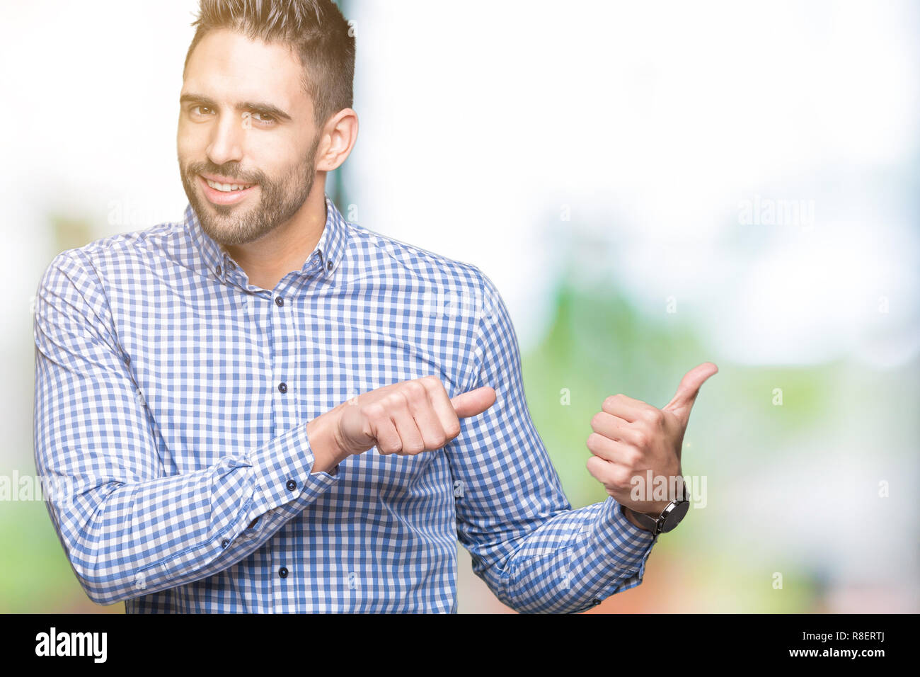 Young handsome man over isolated background Pointing to the back behind ...
