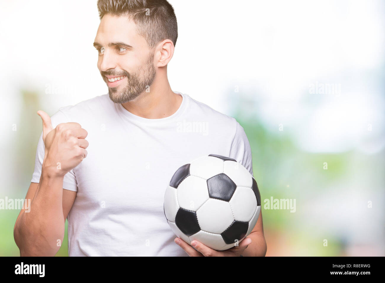 Young man holding soccer football ball over isolated background ...
