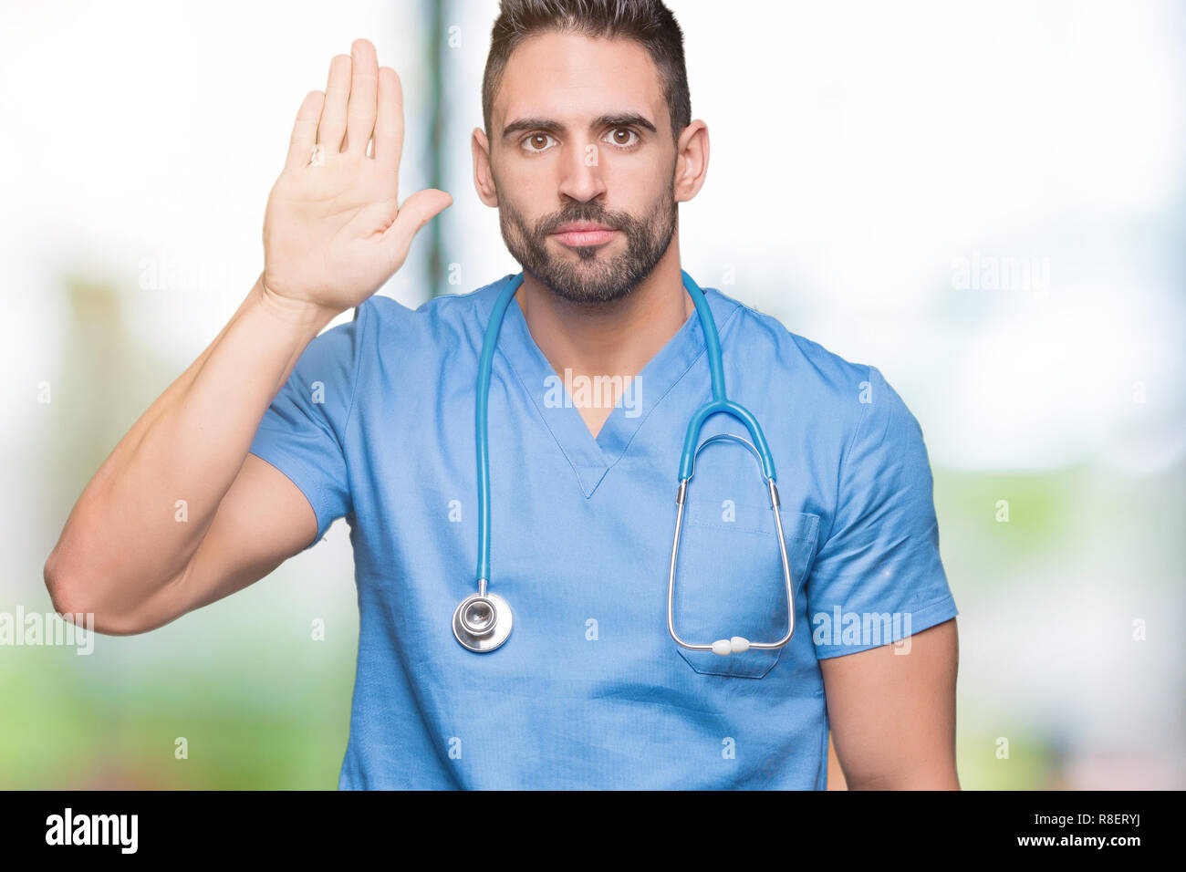 Handsome young doctor surgeon man over isolated background doing stop ...