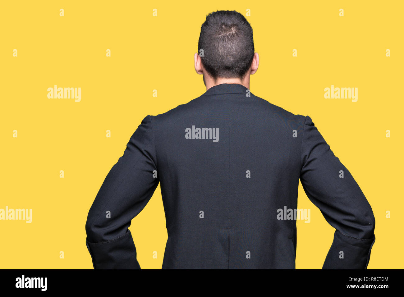 Young Christian priest over isolated background standing backwards ...
