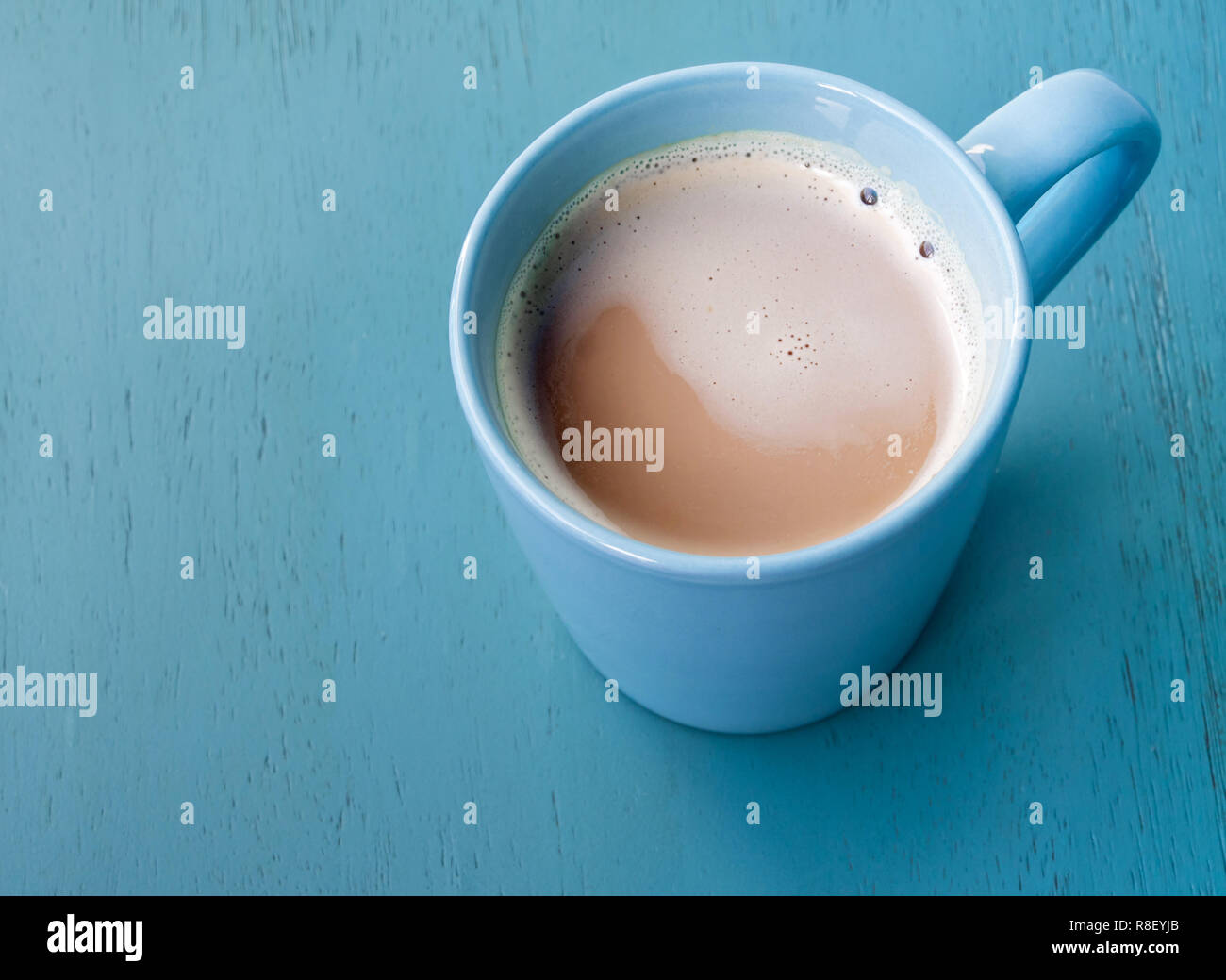 Milk coffee in a blue cup on pastel blue wooden floor Stock Photo - Alamy