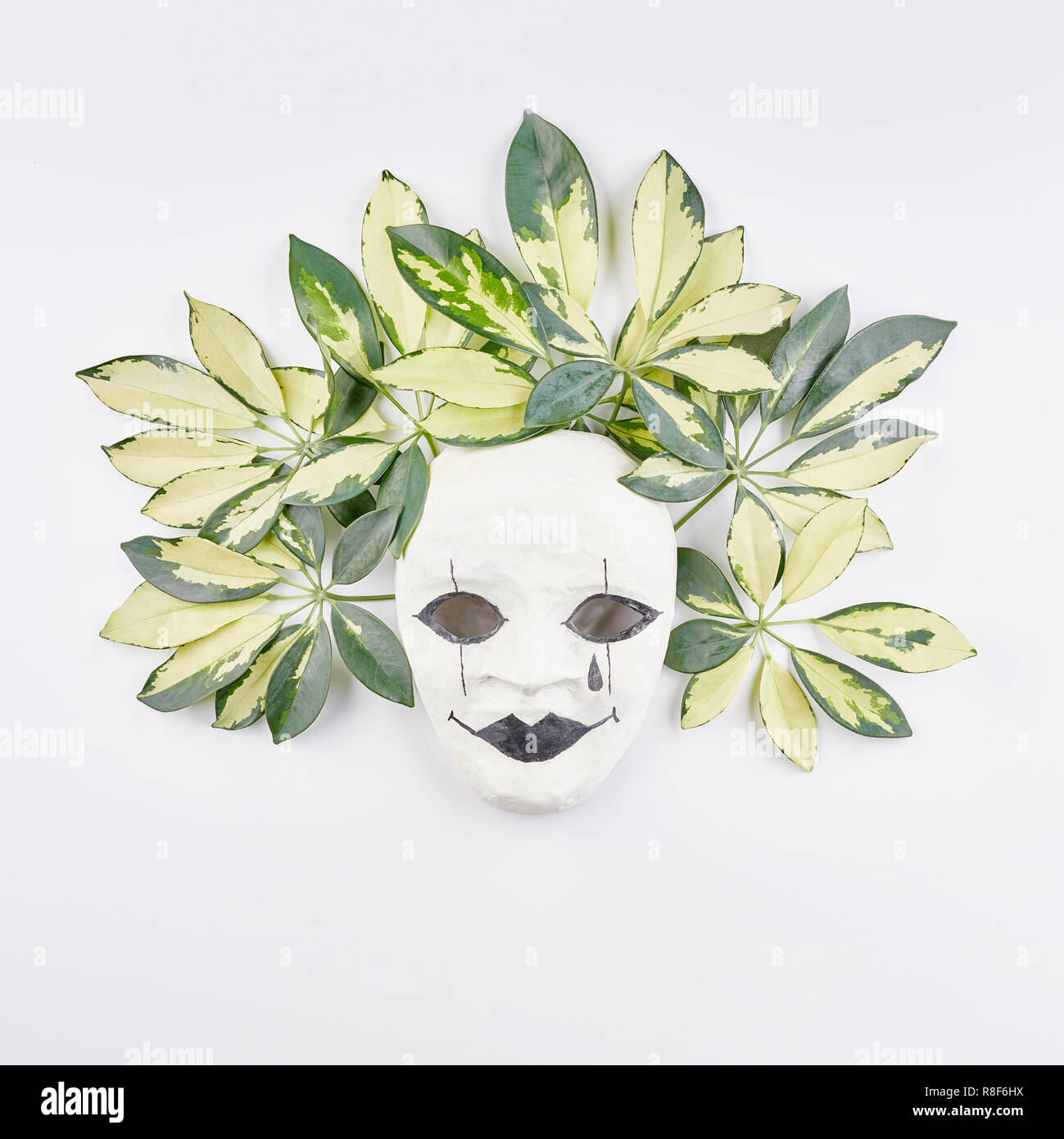 Stylized mask and tropical palm leaves on white background. Flat lay ...