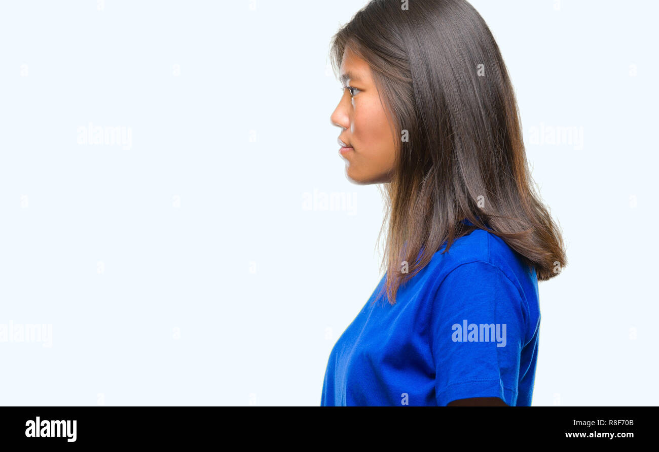 Young asian woman over isolated background looking to side, relax ...