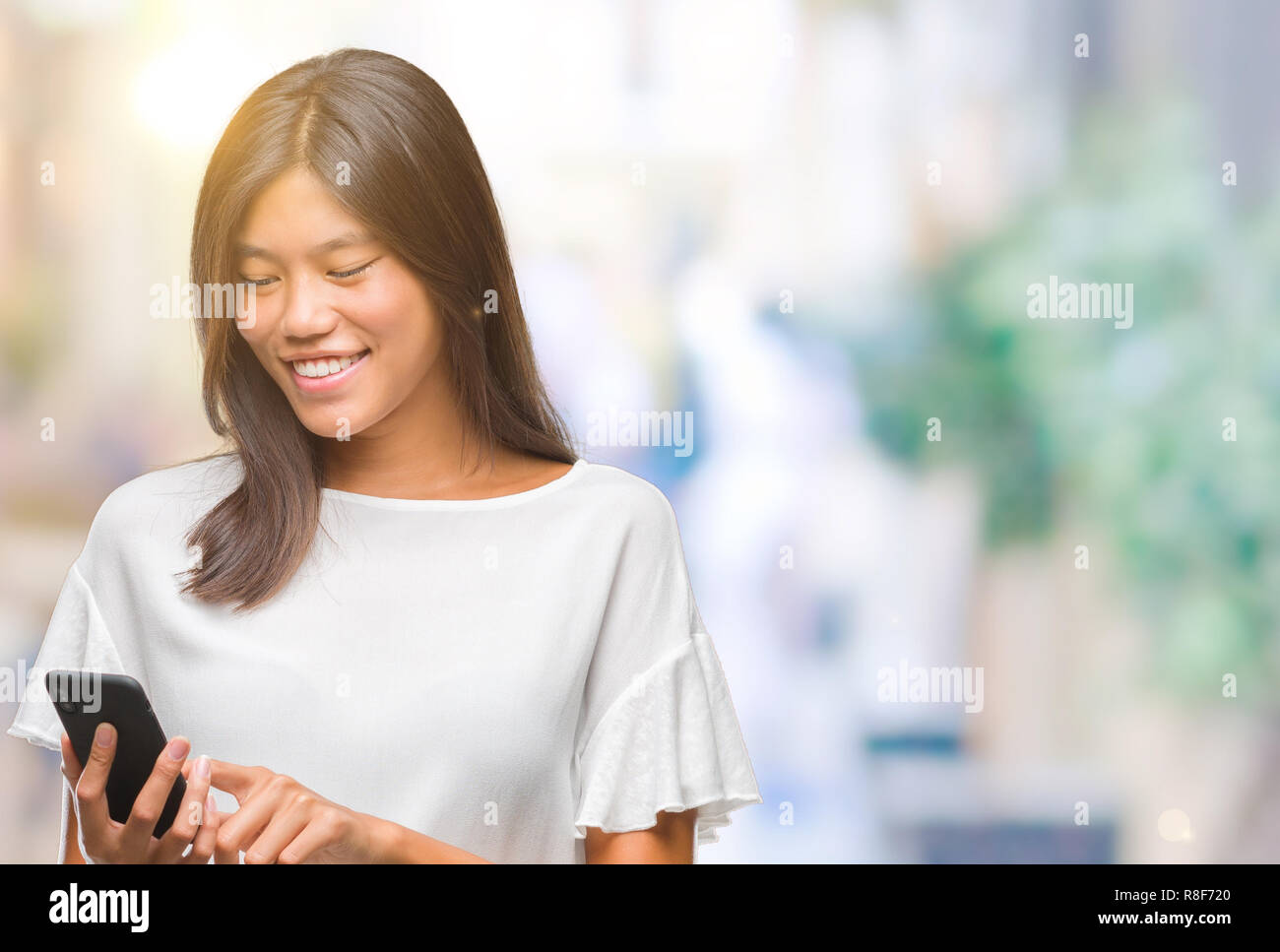 Young asian woman texting using smartphone over isolated background ...