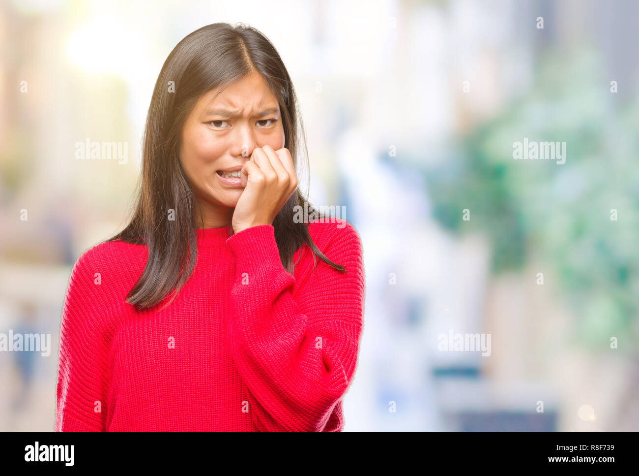 Young asian woman wearing winter sweater over isolated background ...